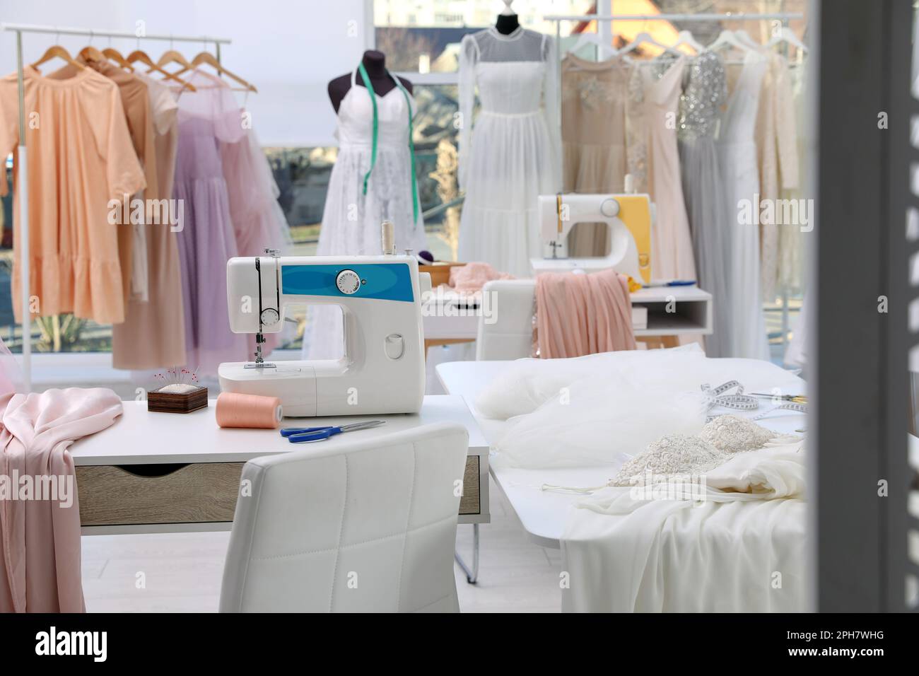 Dressmaking workshop interior with wedding dresses and equipment Stock ...