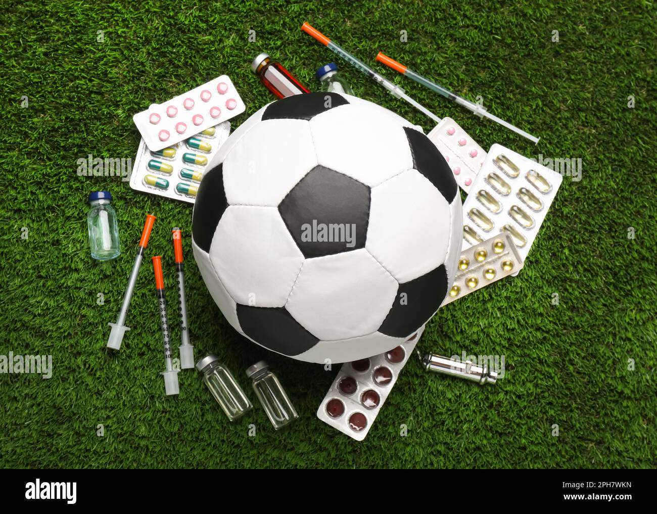 Soccer ball and different drugs on green grass, flat lay. Doping ...
