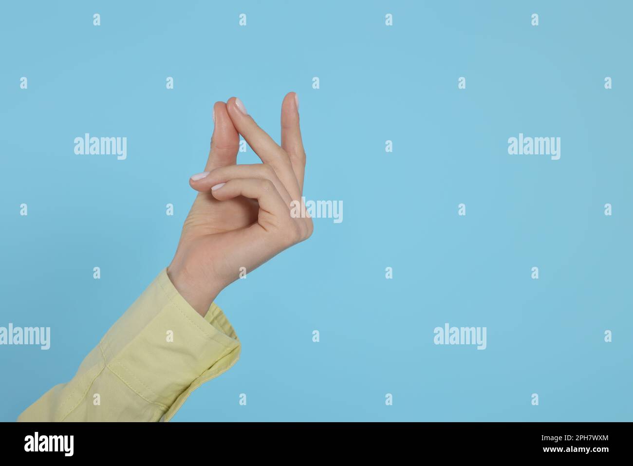 Woman snapping fingers on light blue background, closeup of hand. Space ...
