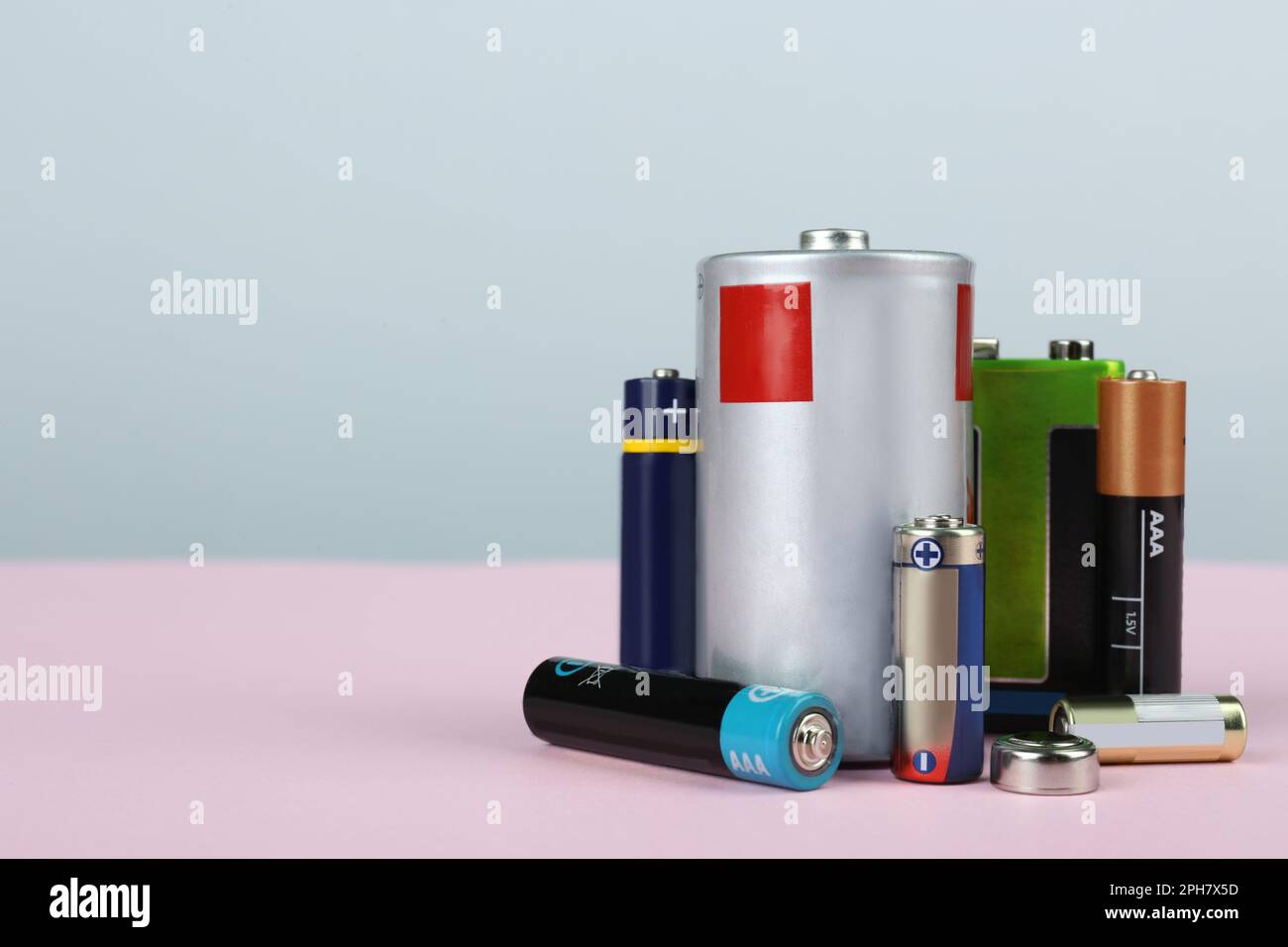 Different types of batteries on color background, space for text Stock ...