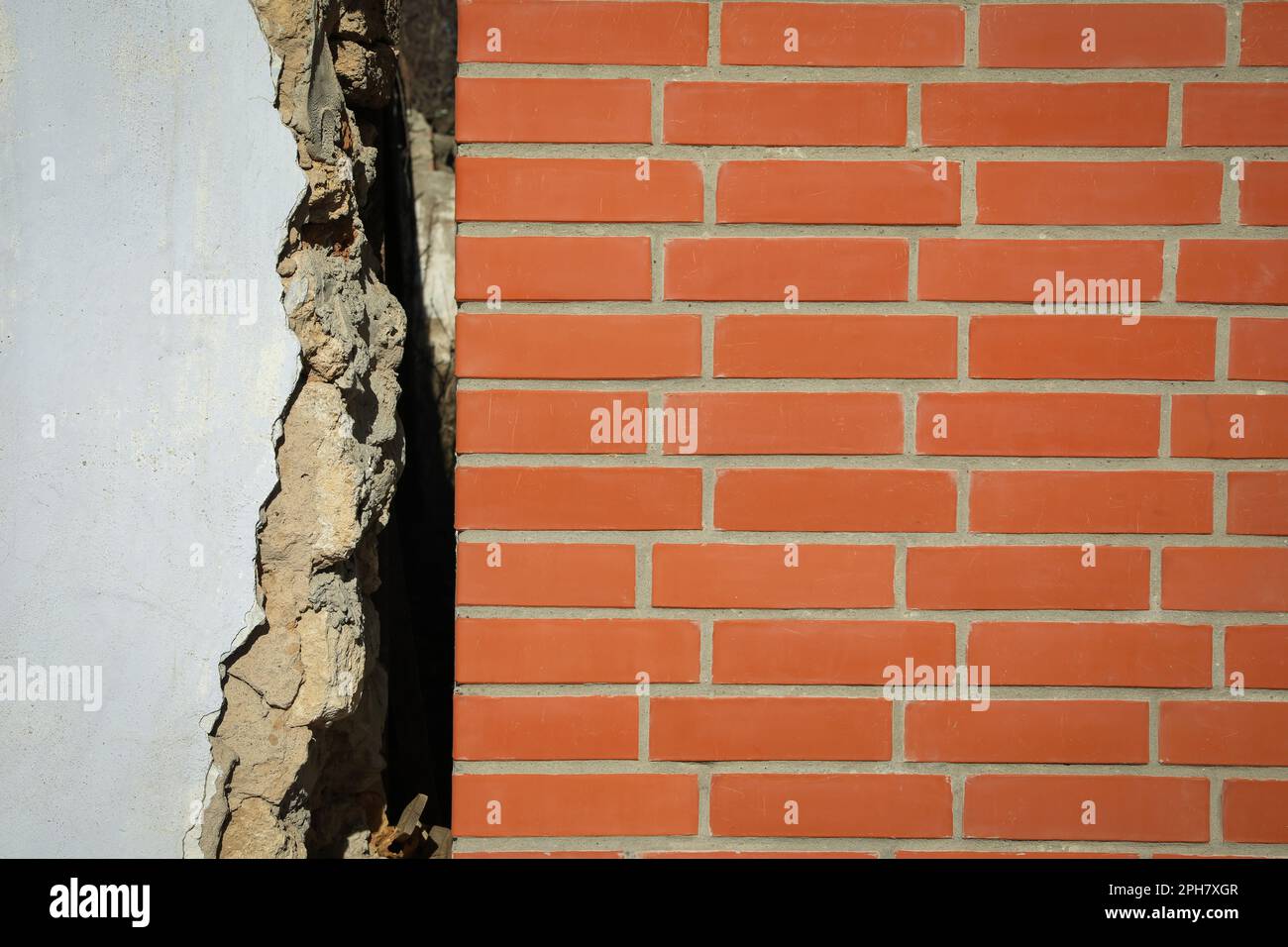 Old white building near new brick wall. Earthquake aftermath Stock ...