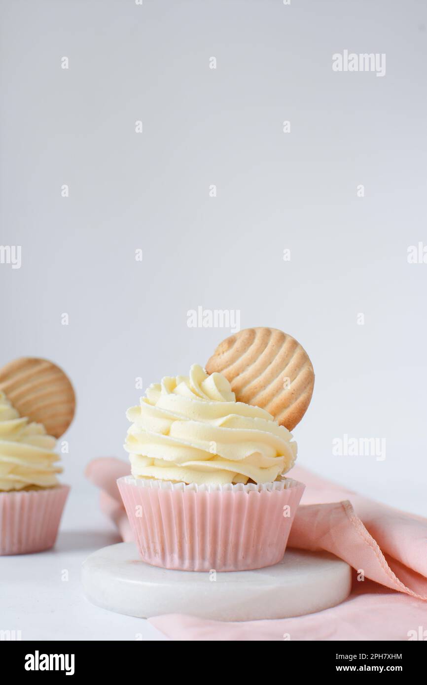 Pink cupcakes with tall american buttercream swirl and cookie garnish ...