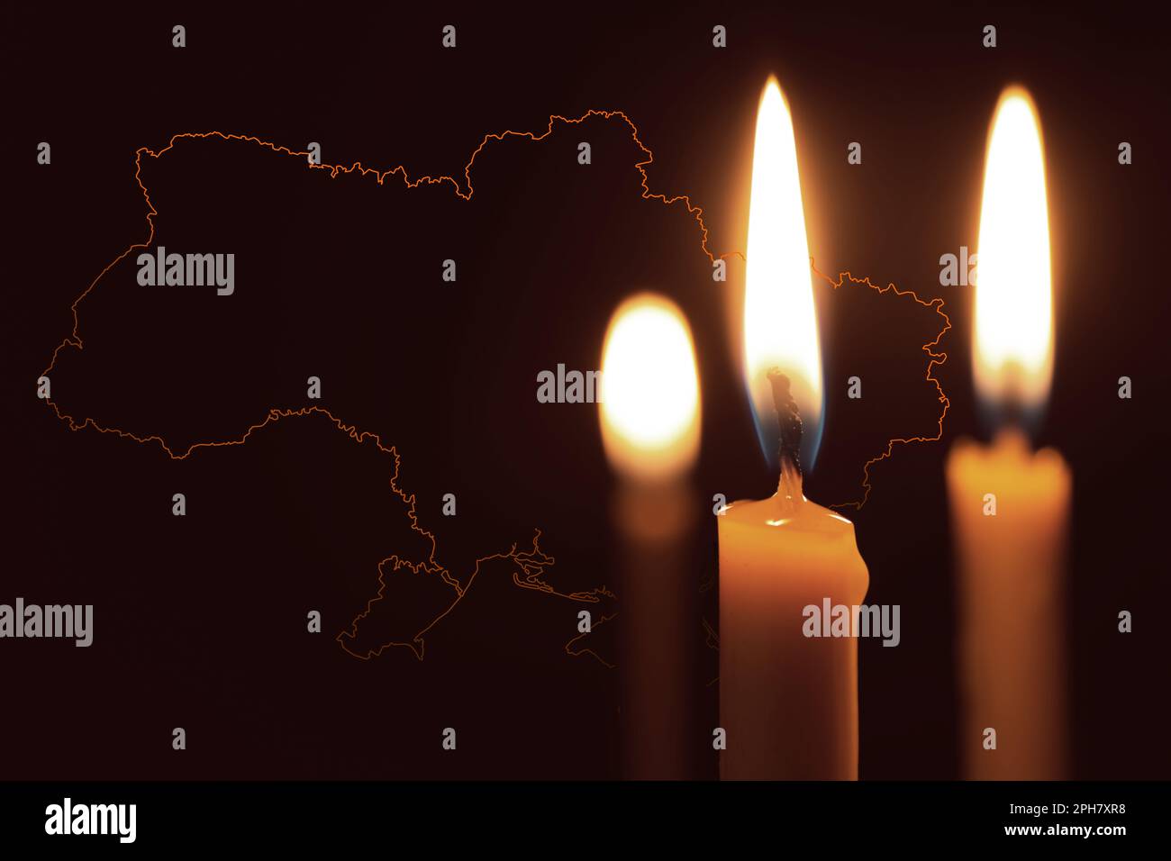Burning candles and outline map of Ukraine on dark background, closeup ...