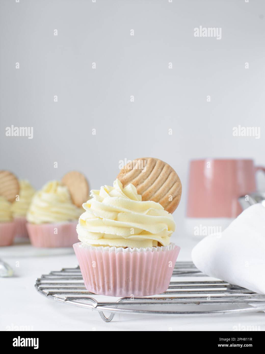 Pink cupcakes with tall american buttercream swirl and cookie garnish ...