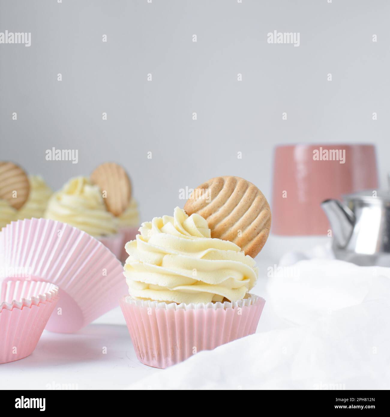 Pink cupcakes with tall american buttercream swirl and cookie garnish ...
