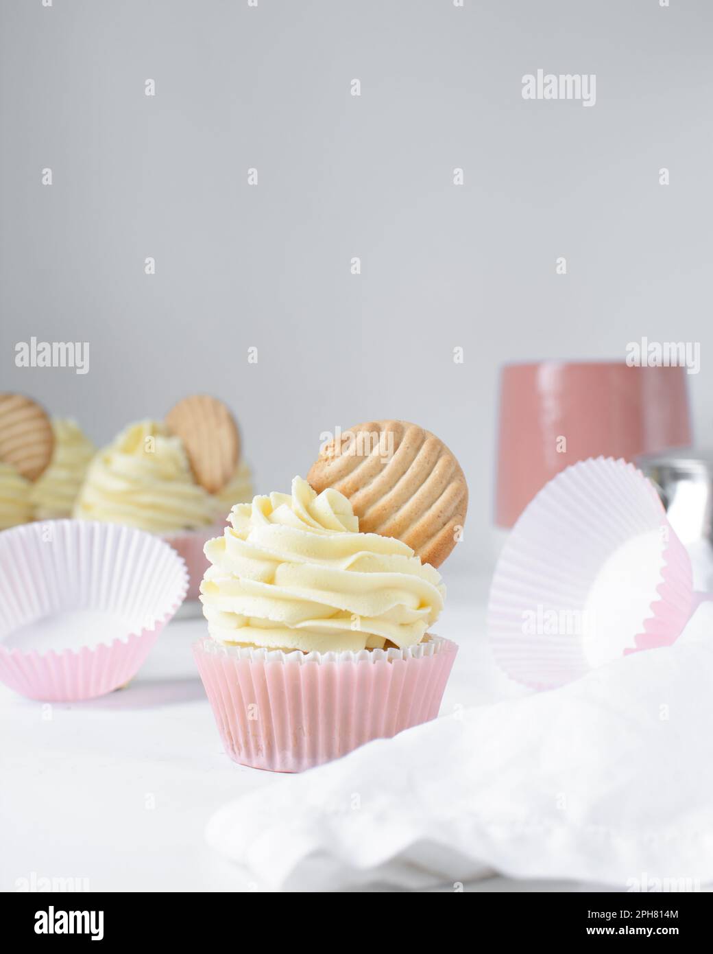 Pink cupcakes with tall american buttercream swirl and cookie garnish ...