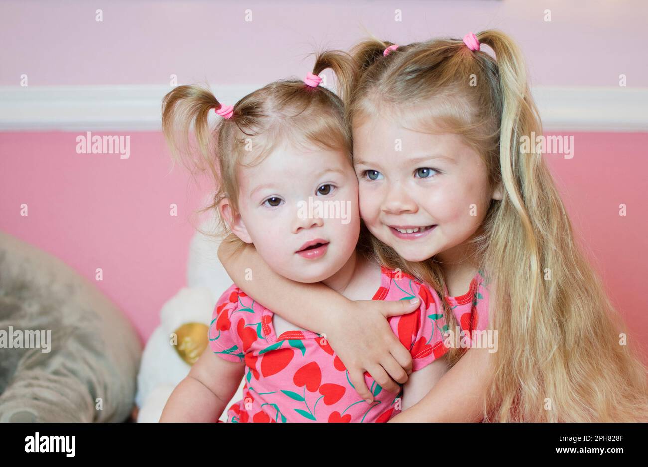 Two caucasian sisters in matching clothes hugging. Sister's love ...