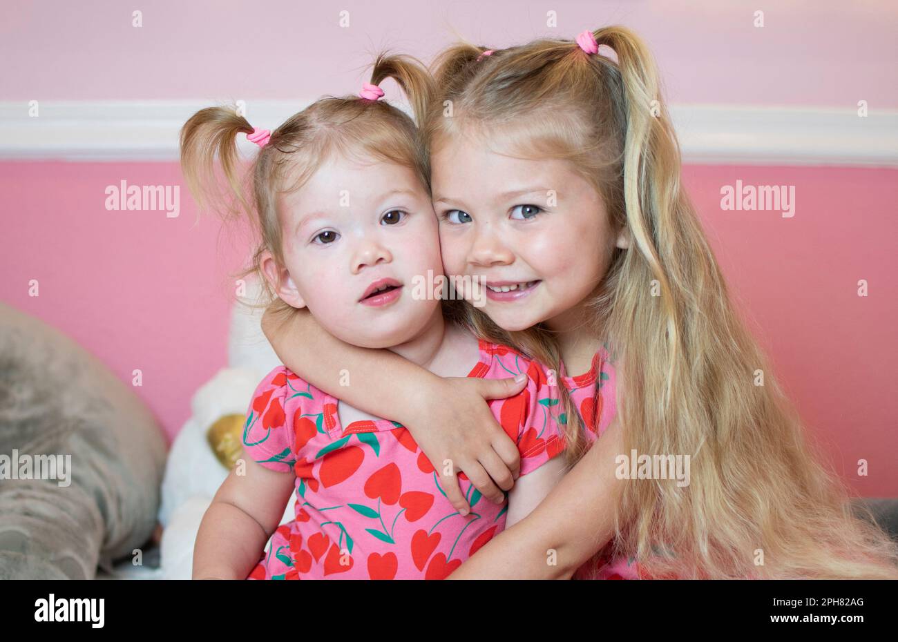 Two caucasian sisters in matching clothes hugging. Sister's love ...