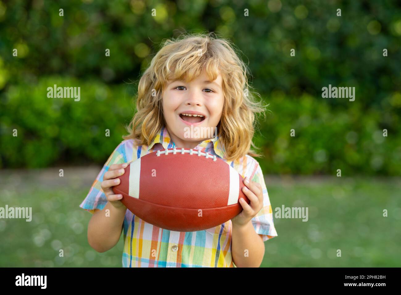 Football game, rugby, american football. Boy with rugby ball. Child boy ...