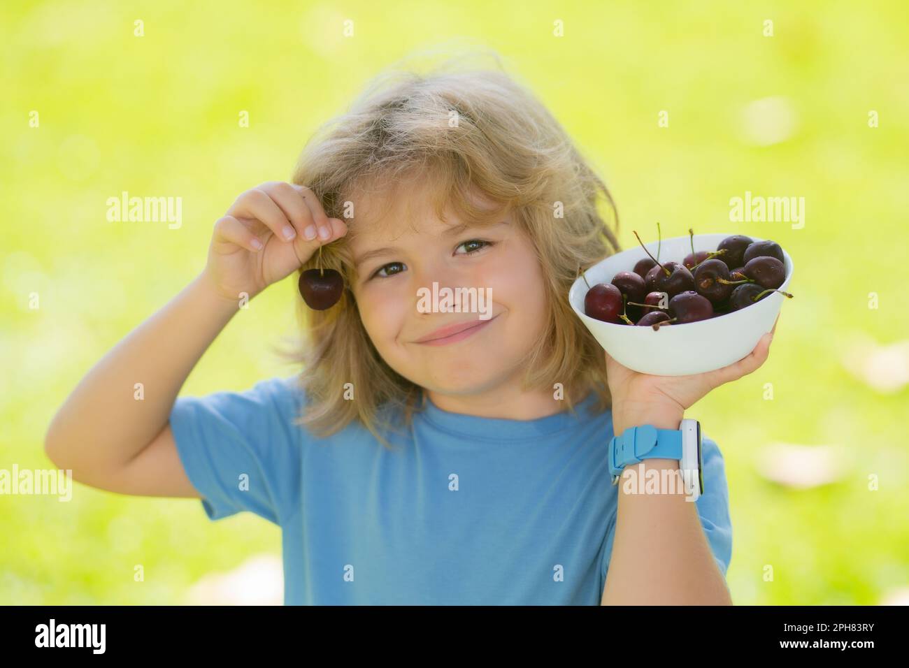 Summer child face. Cherry fot kids. Happy kid eating ripe, sweet, juicy ...
