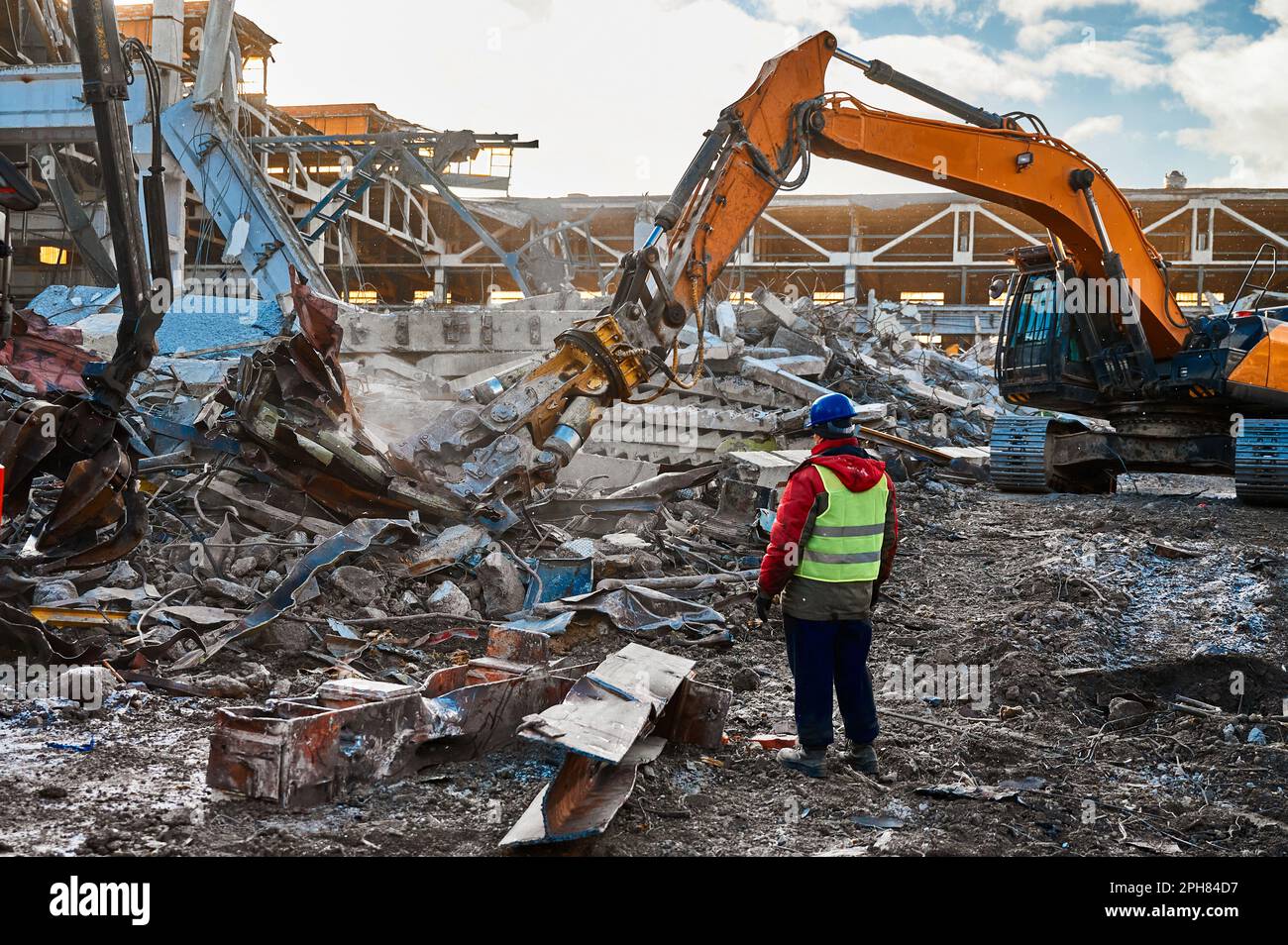 Excavator destroyer removes debris under worker control Stock Photo - Alamy
