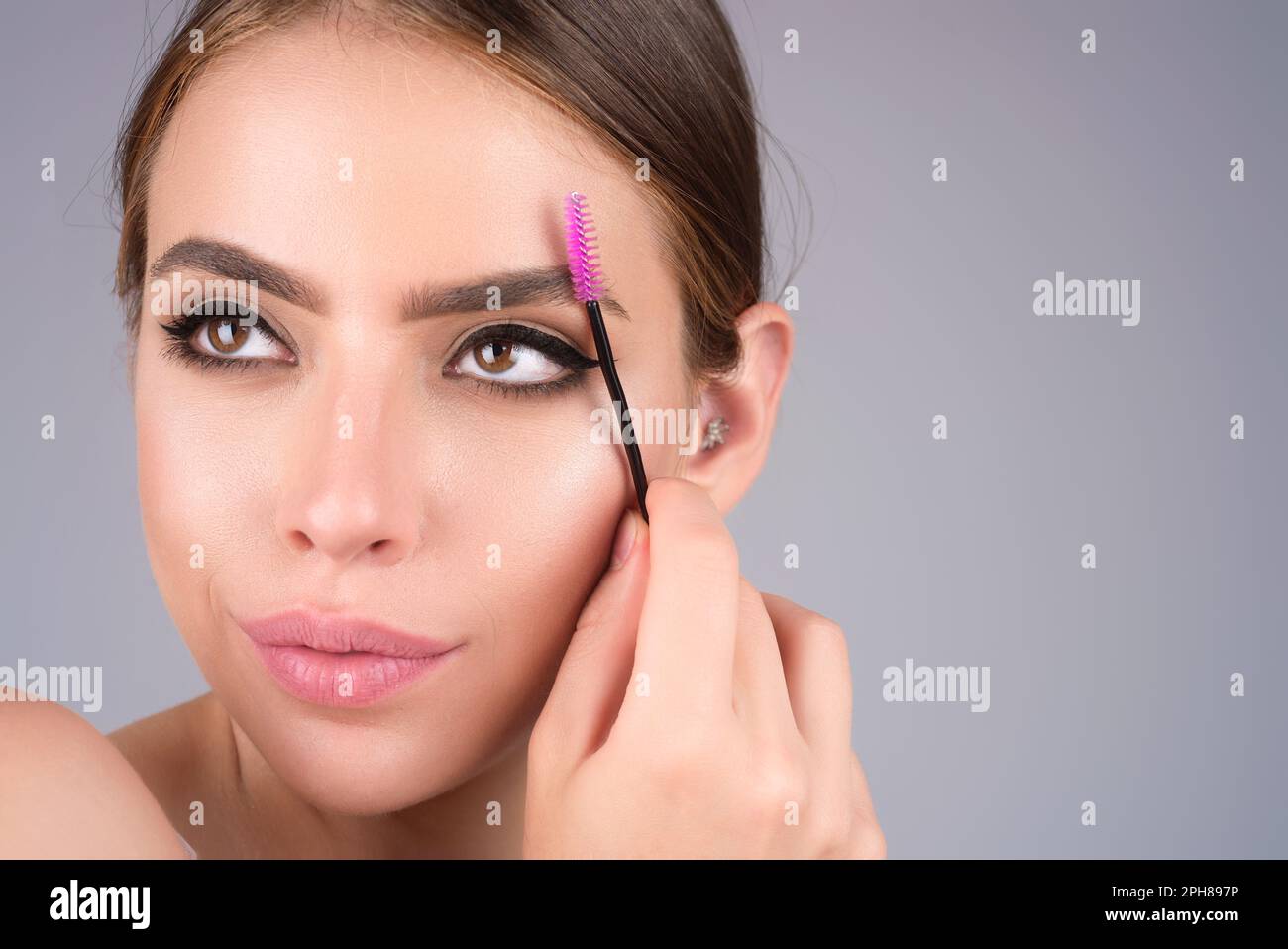 Perfect eyebrows. Natural beauty brows. Eyebrows coloring and lamination. Woman combing eyebrows ...