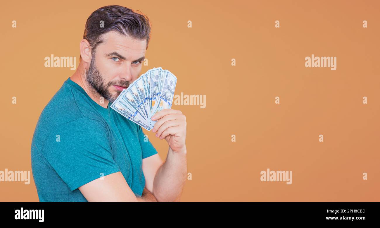 Handsome man holding money isolated over beige studio, banner. Money in ...