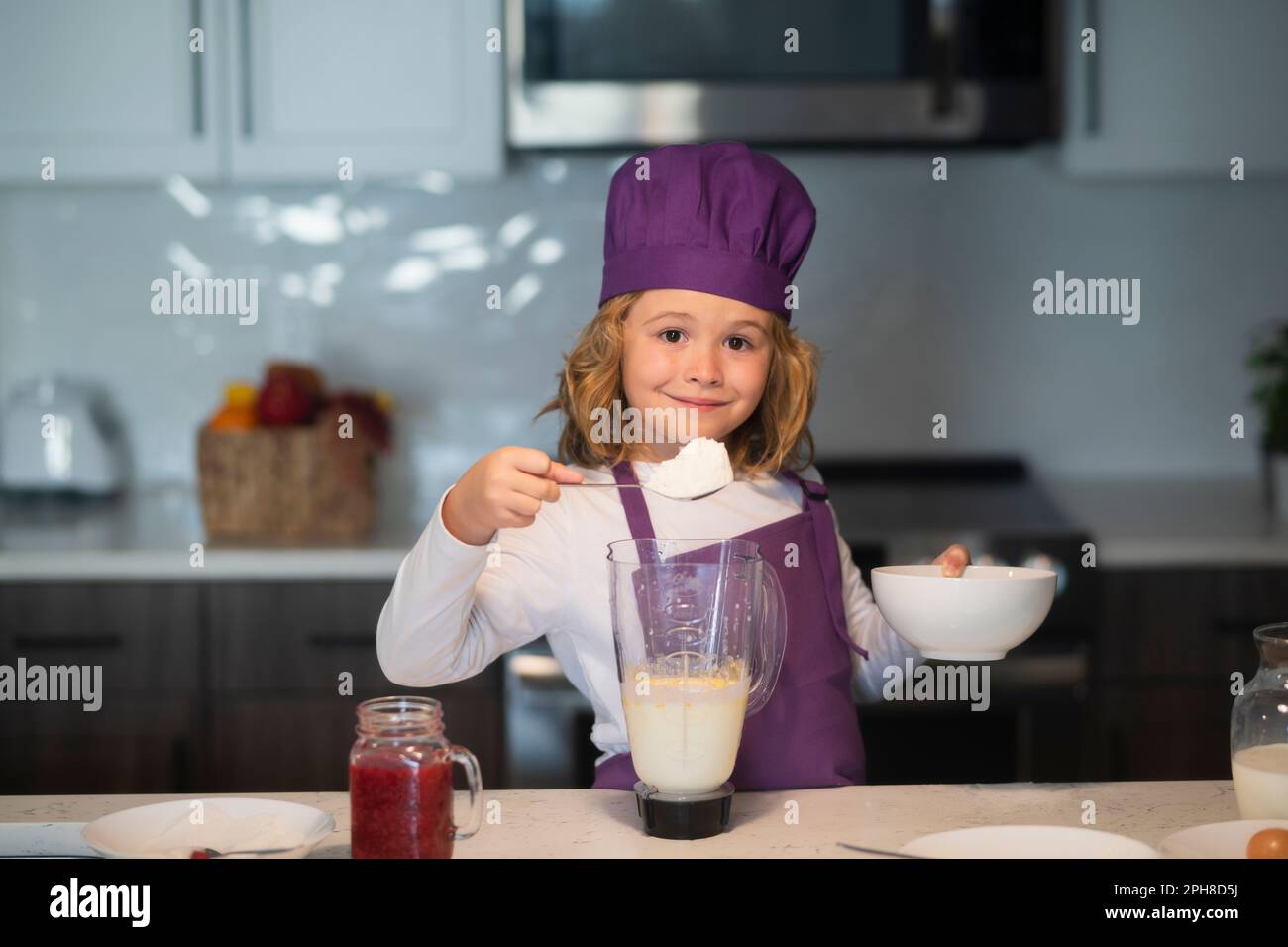 Child chef cooking meal. Child chef cook is learning how to make a cake ...