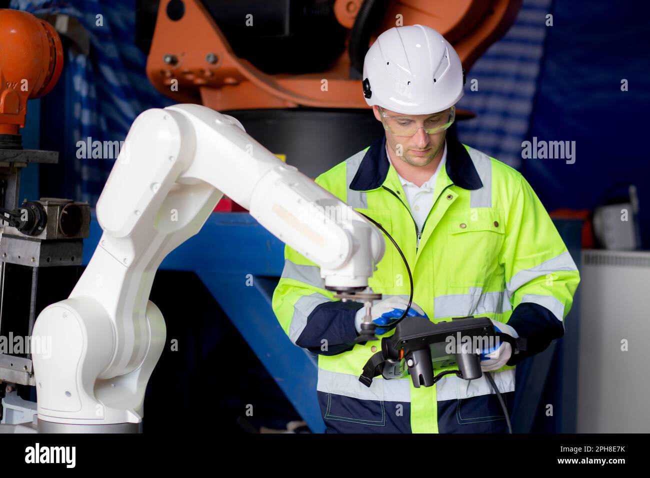 Young engineer man checking and maintenance machine robot arms ...