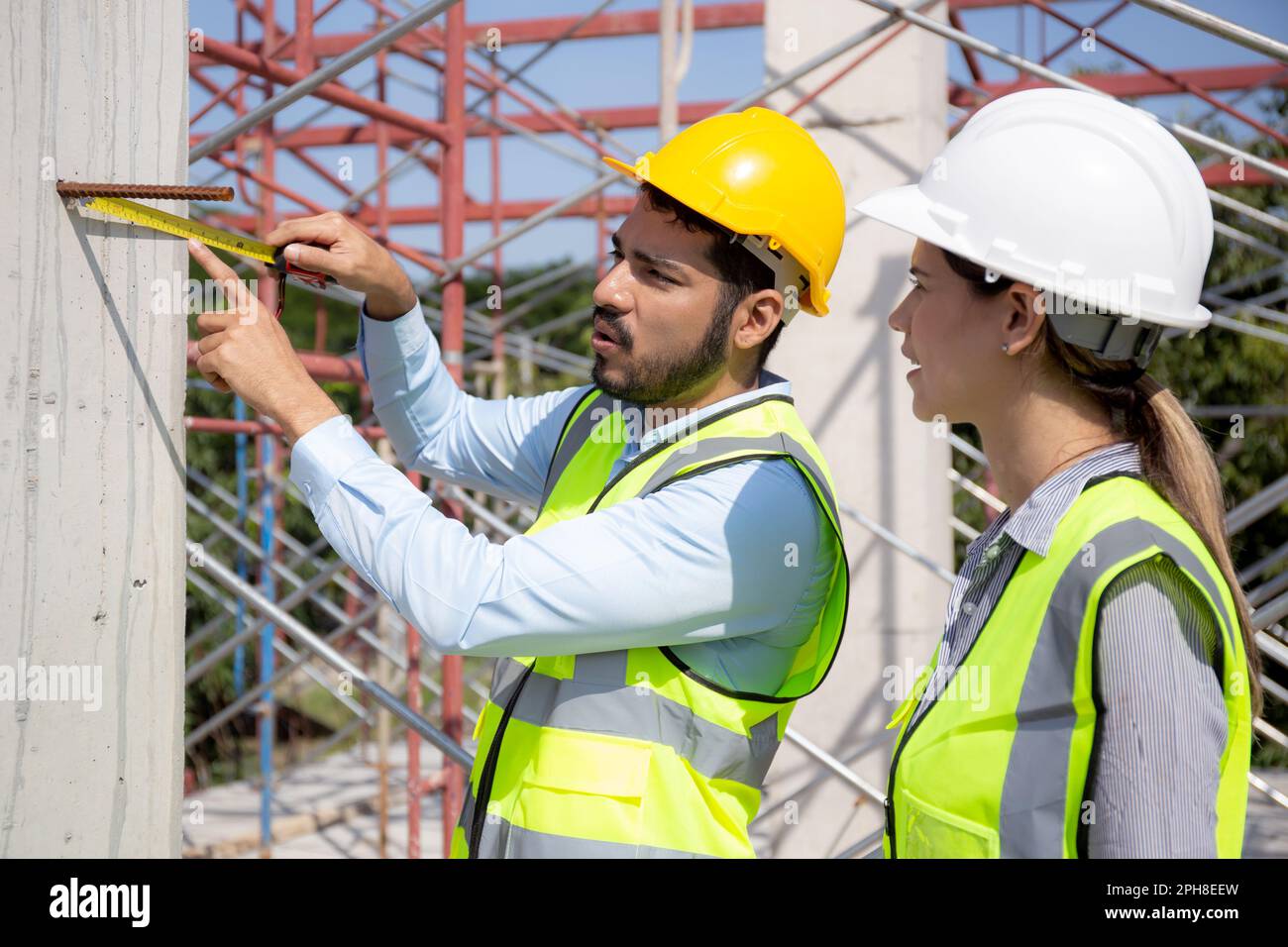 Engineer young man and woman using tape measure for check and examining ...