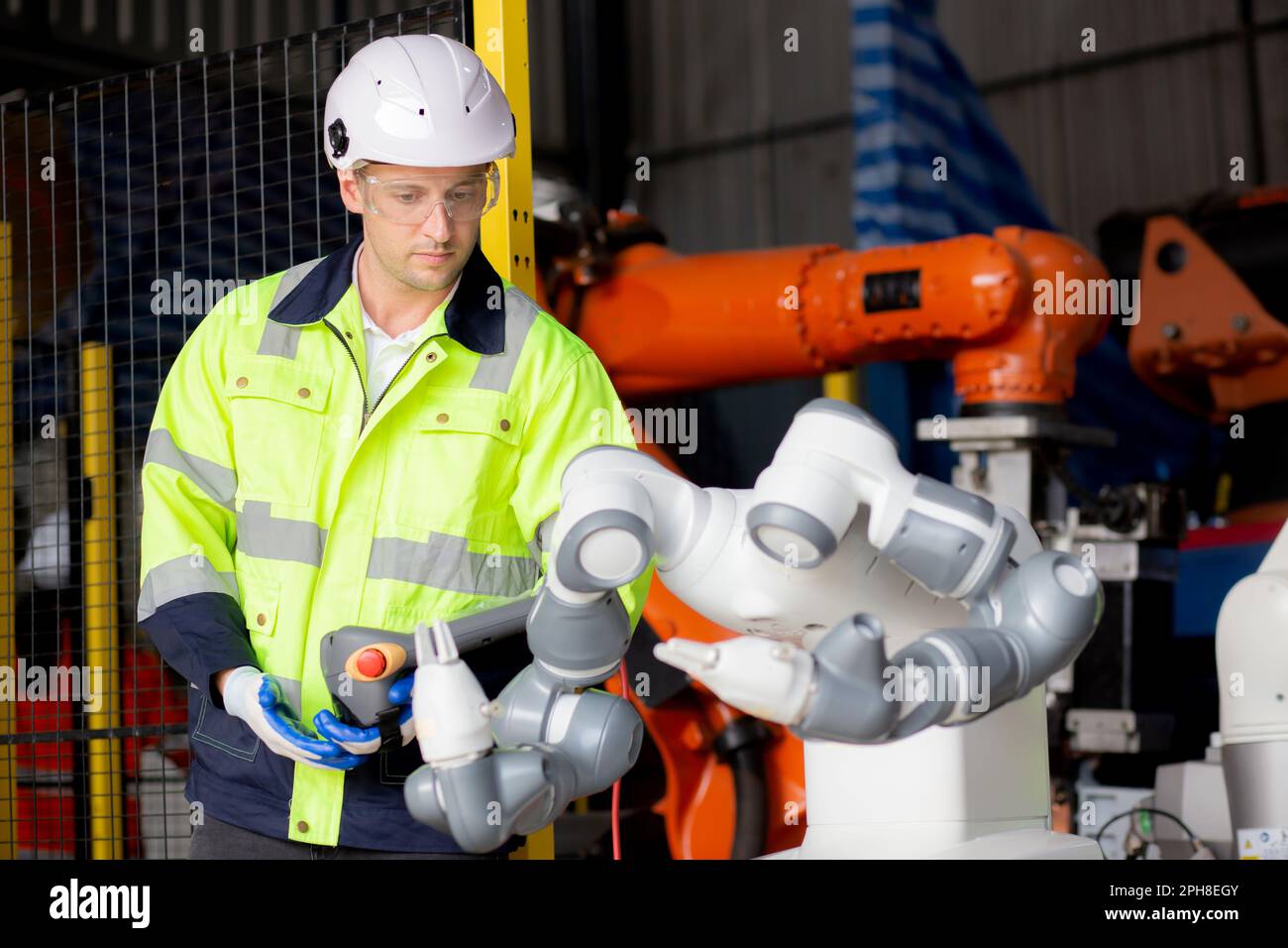Young engineer man checking and maintenance machine robot arms ...