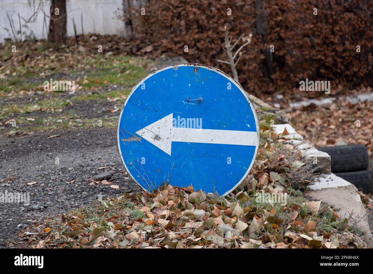 left turn sign stands on the road in autumn without a pillar on the ...
