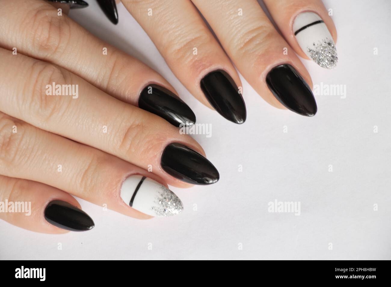 extended nails with black and white color manicure on a white ...