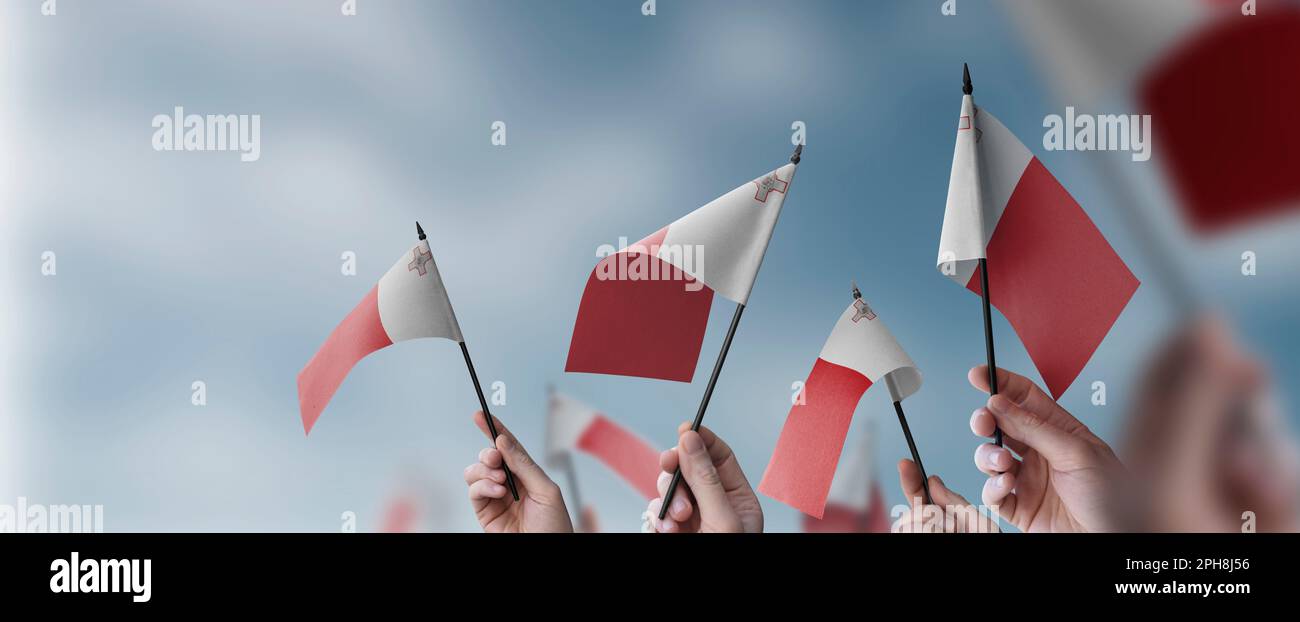 A group of people holding small flags of the Malta in their hands Stock ...