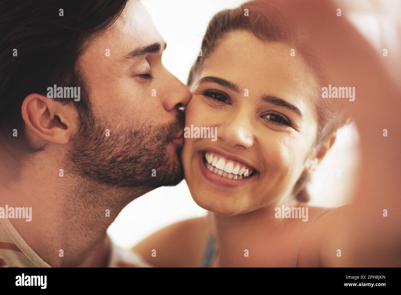 They are picture perfect. an affectionate young couple bonding at home ...