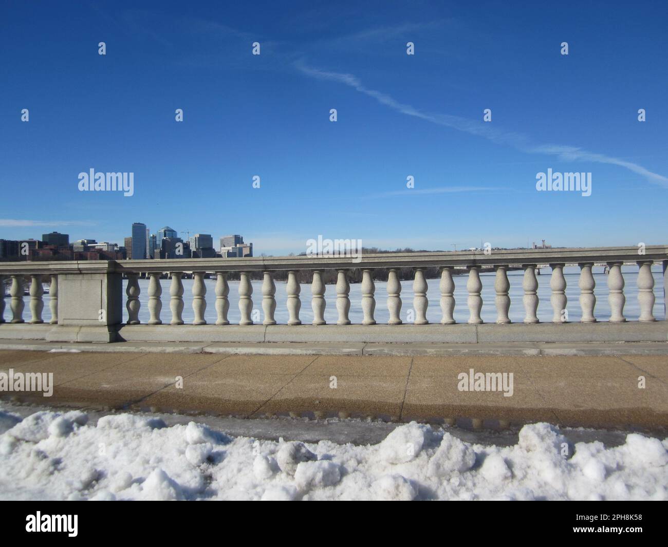 A scenic view of a concrete bridge spanning a snowy street over a body ...
