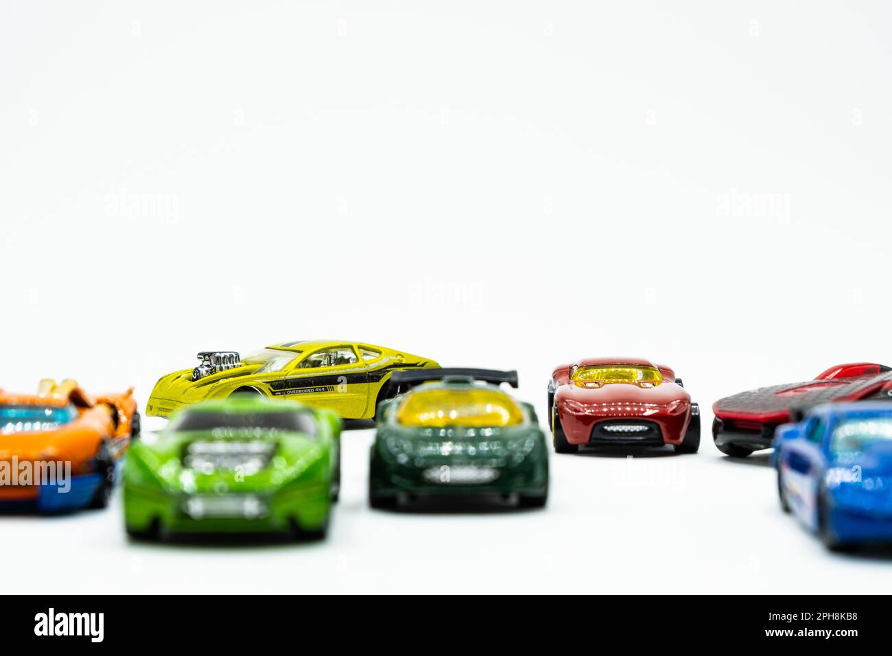 Racing toy cars of various colors scattered on a white background Stock ...