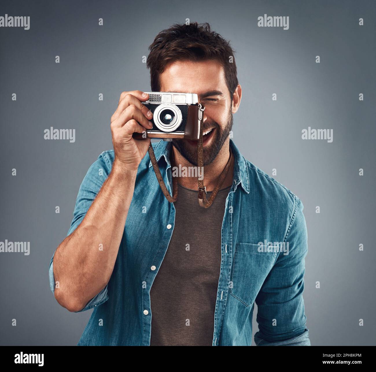 The camera loves you. Studio shot of a handsome young man using a ...