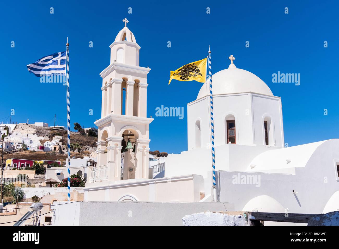 Church and bell tower in typical Greek style in Santorini with flag of ...