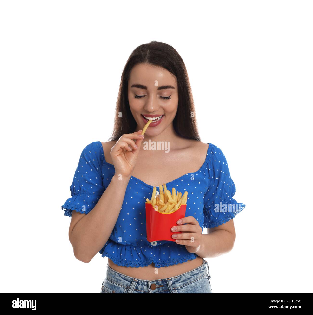 Beautiful young woman eating French fries on white background Stock ...