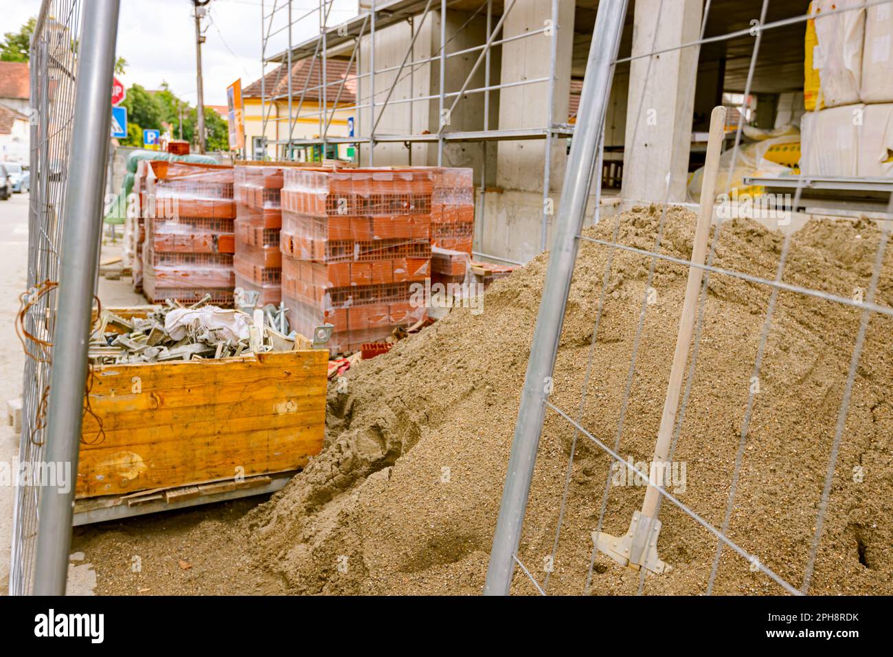 Wire fence on construction site, hill of gravel with stuck shovel ...