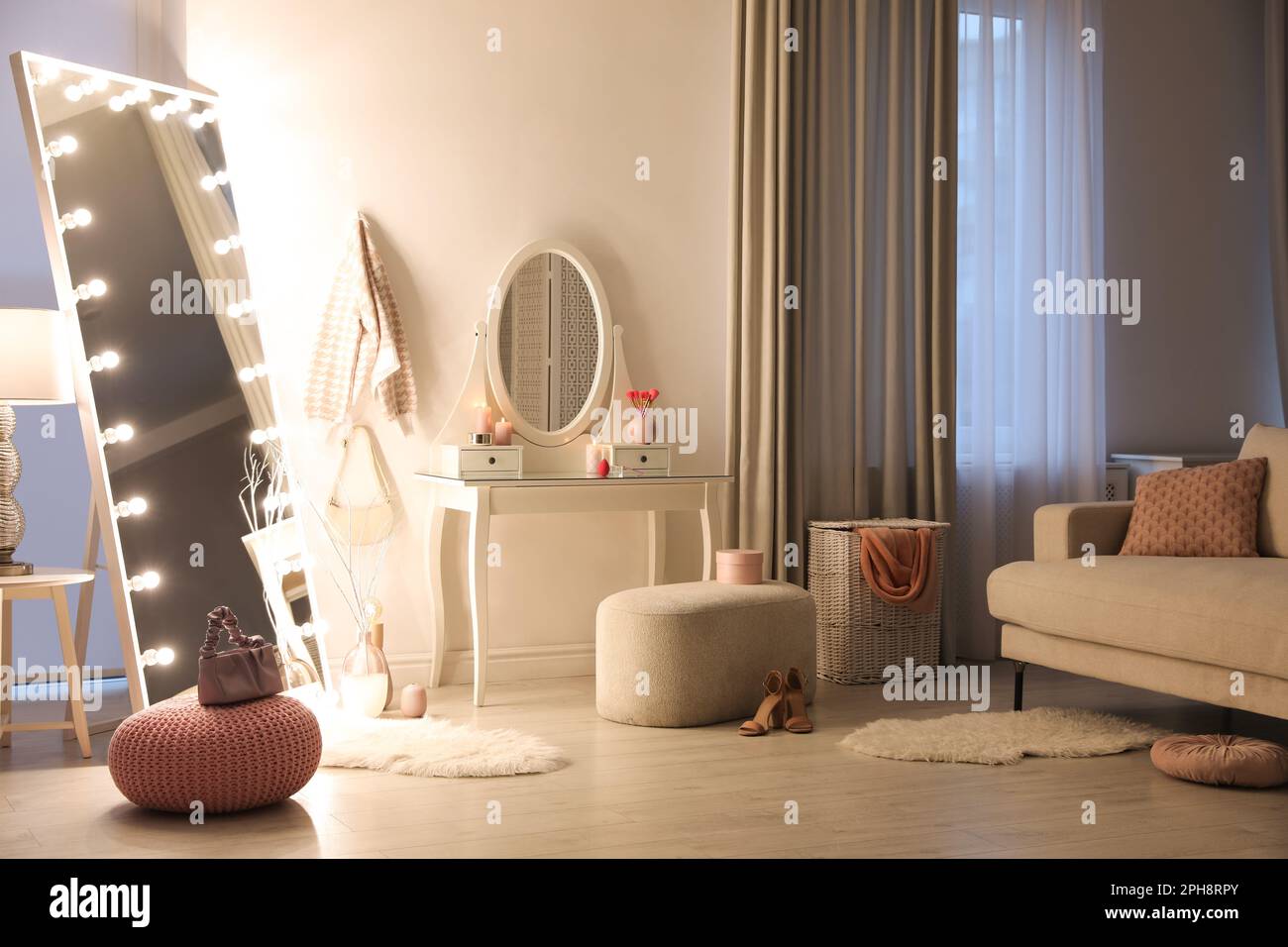 Large mirror with light bulbs and dressing table in stylish room ...