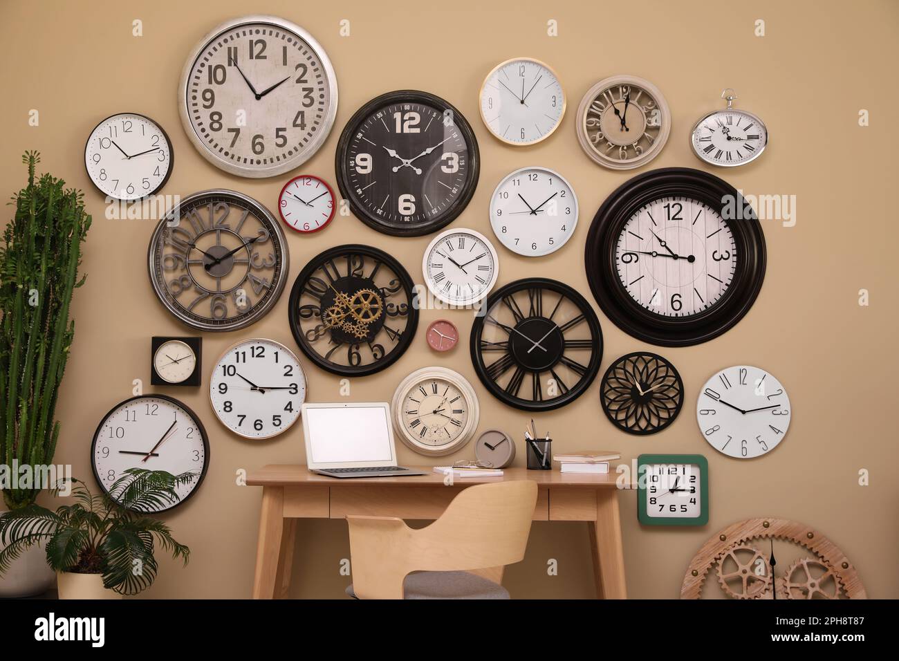 Stylish room interior with collection of wall clocks and workplace ...