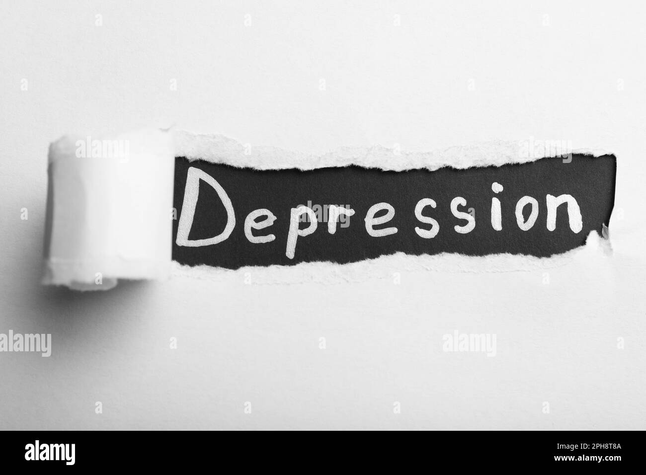 Word Depression on black background, view through hole in torn white ...