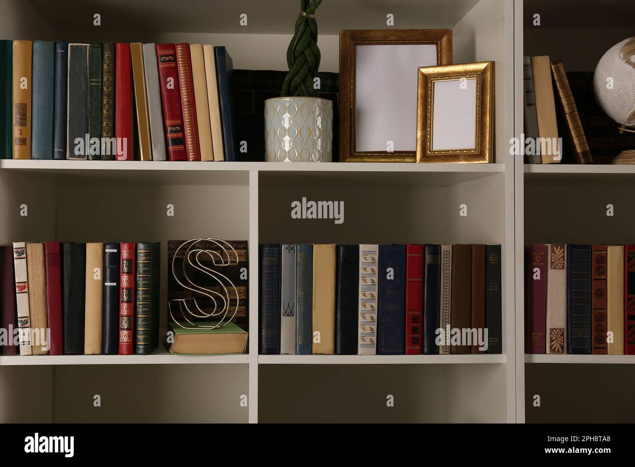Collection of books and decor elements on shelves. Home library Stock ...