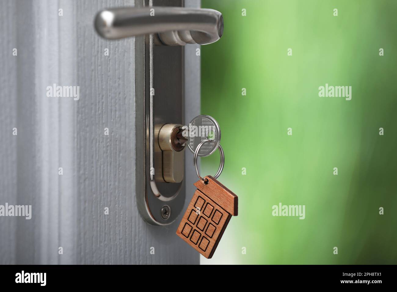 Open door with key on blurred background, closeup Stock Photo - Alamy