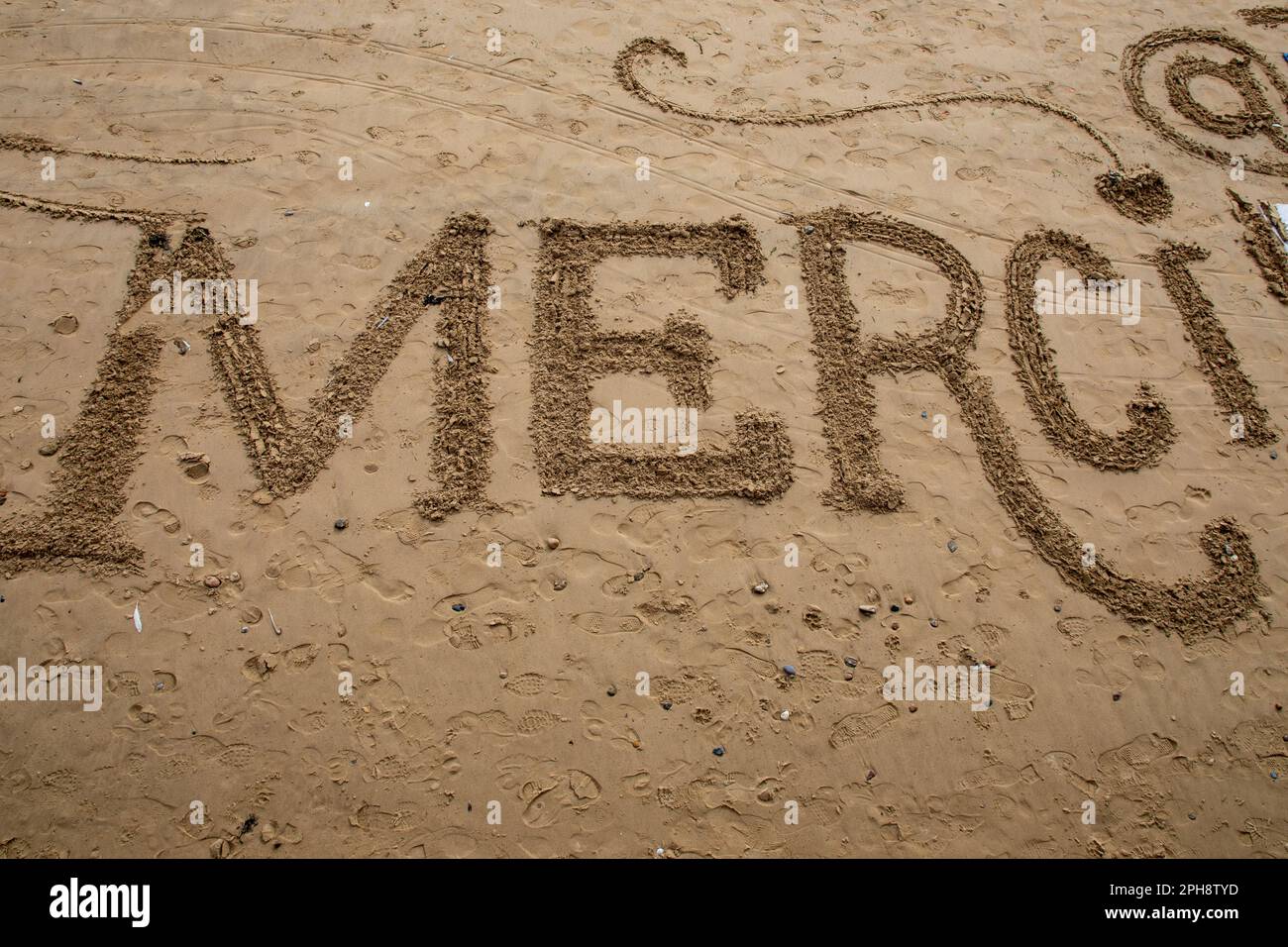 merci french sign means Thank you text written on the sand beach Stock ...