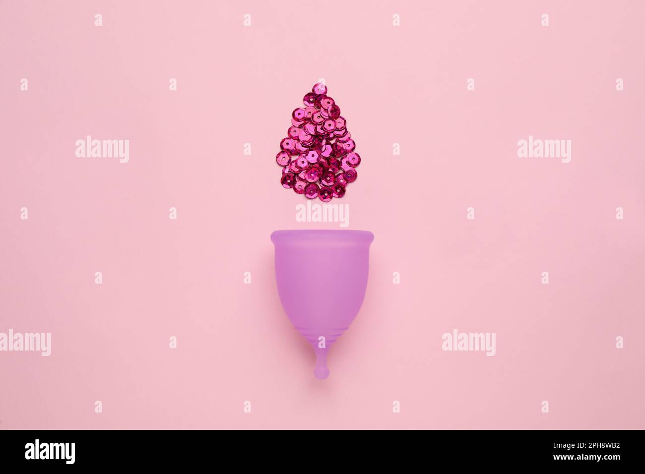 Menstrual cup near drop made of sequins on pink background, flat lay ...