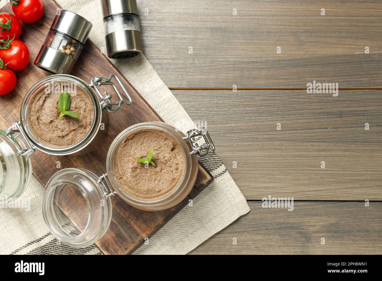Glass jars with delicious liver pate on wooden table, top view. Space ...