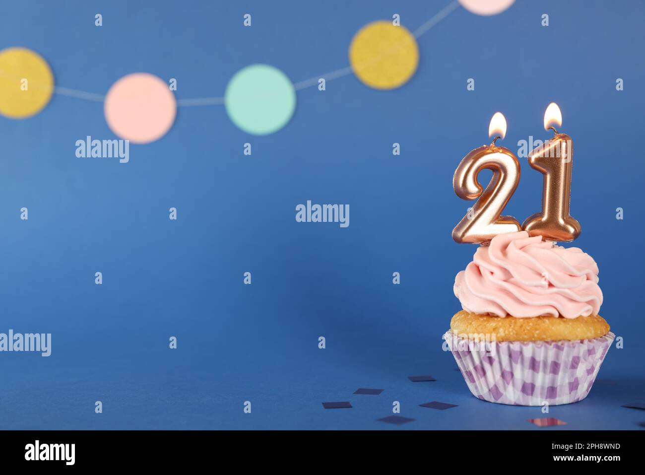 Delicious cupcake with number shaped candles on blue background, space ...