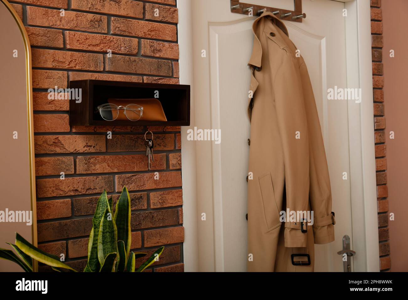 Stylish hanger for keys on brick wall in hallway Stock Photo - Alamy