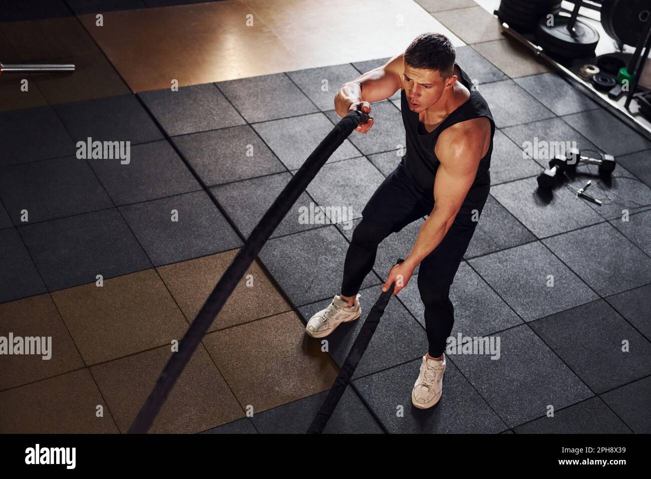 Strong man in sportive clothes have workout day in the gym by using ...