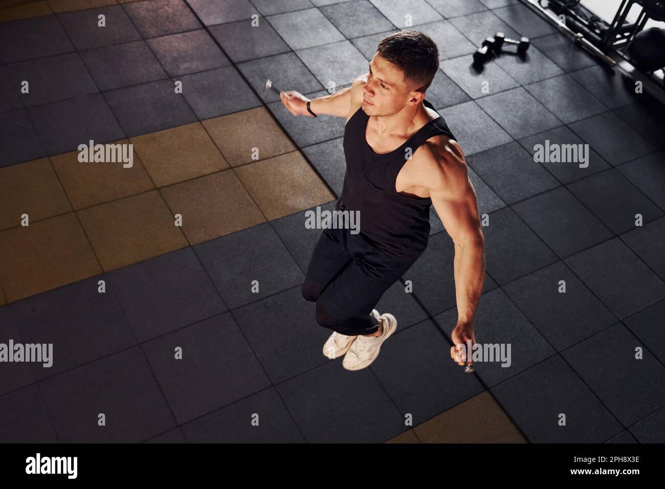 Strong man in sportive clothes have workout day in the gym by using ...