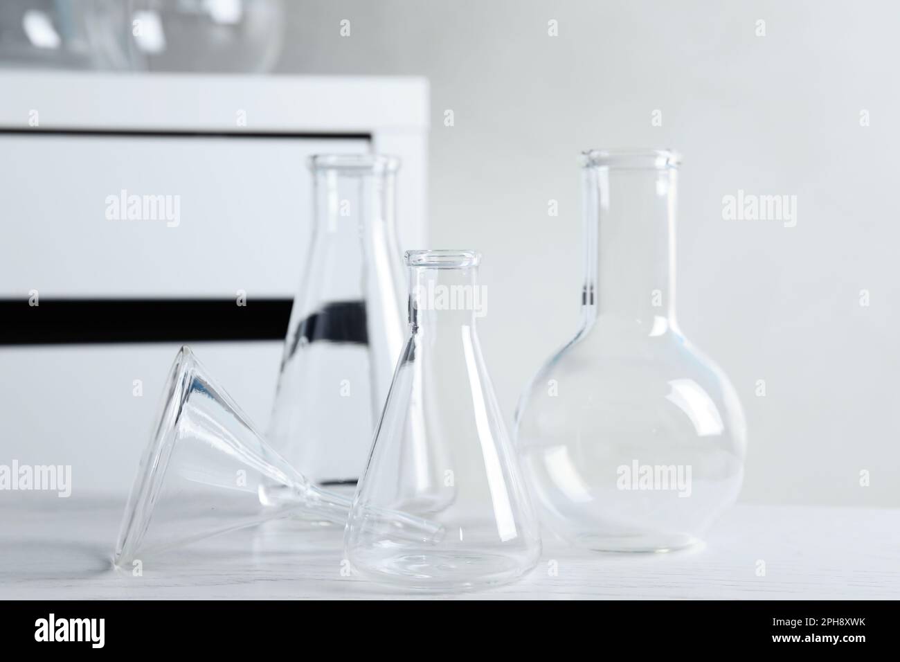 Set of laboratory glassware on white table indoors Stock Photo - Alamy
