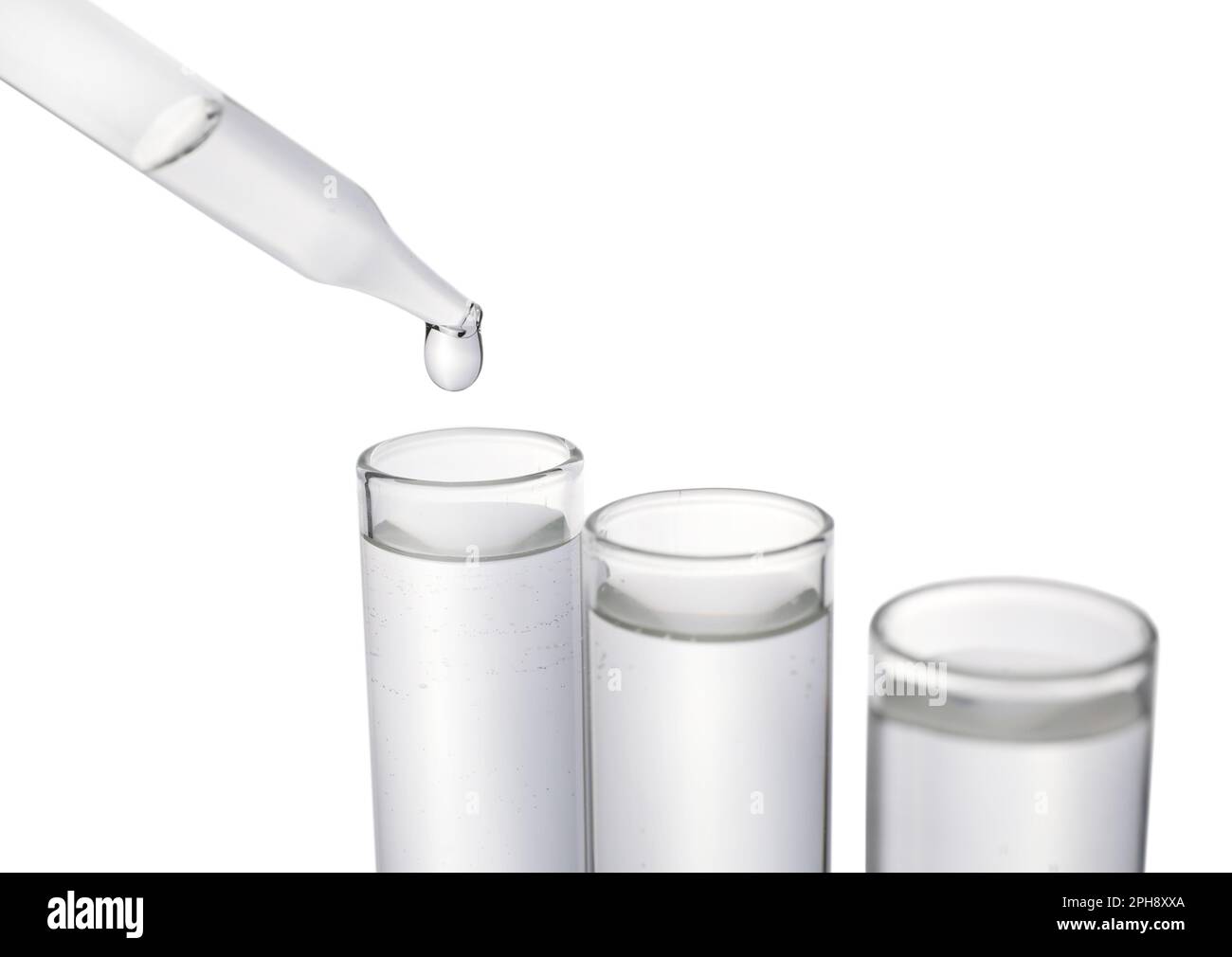 Dripping transparent liquid into test tube on white background, closeup ...