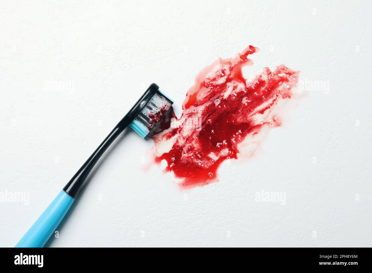 Toothbrush with paste and blood on white table, top view. Gum ...