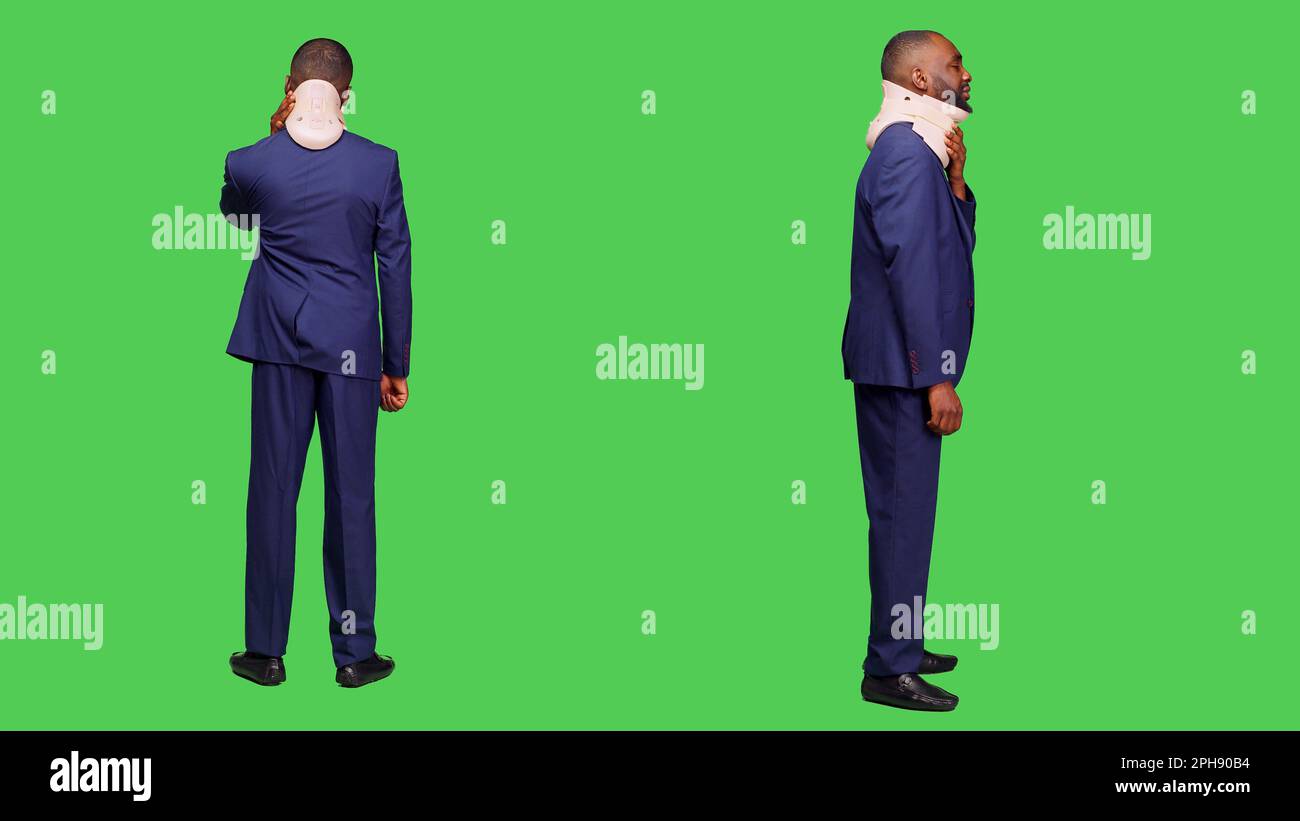 Hurt young worker wearing office suit and cervical collar standing over ...