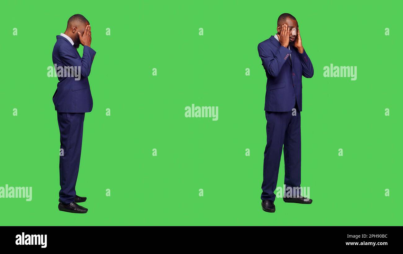 Male entrepreneur dealing with headache over full body green screen ...