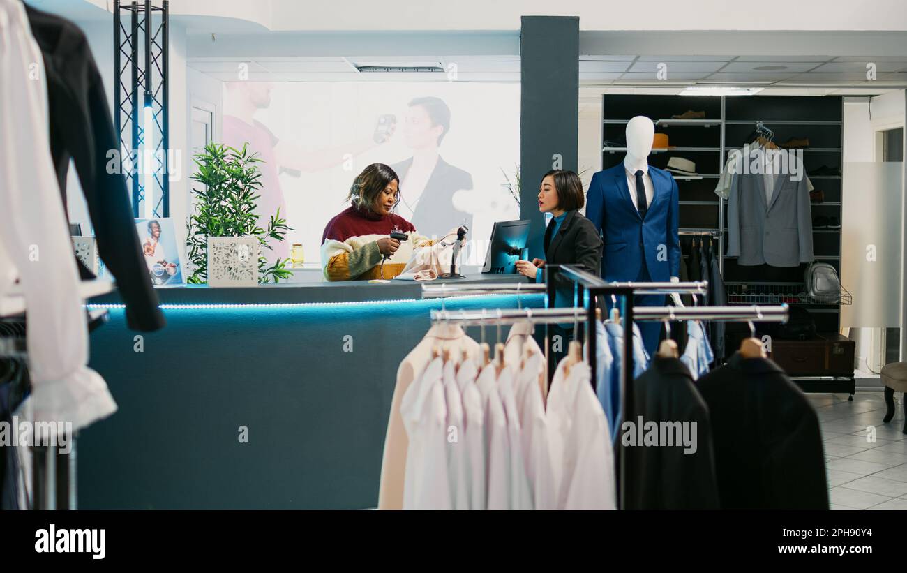Asian person paying for merchandise at cash register, using card at pos ...