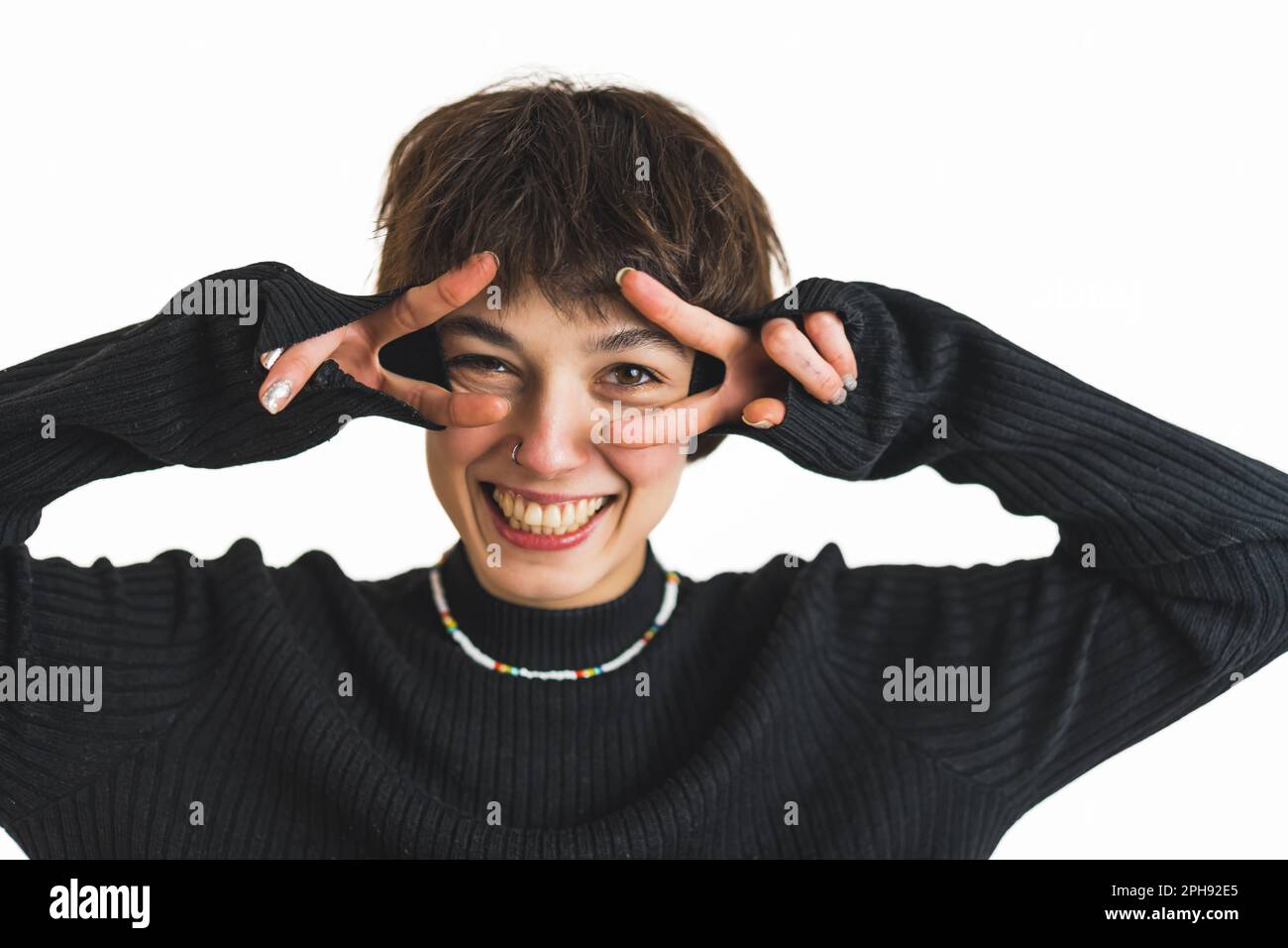 Smiling short haired adult girl in black sweater gesturing with both ...